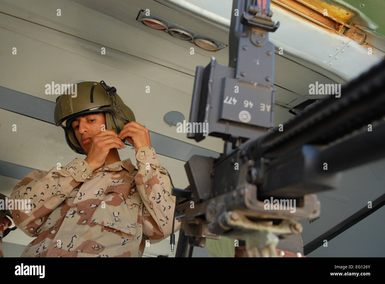 An Iraqi air force aerial gunner trainee puts on his gunner's helmet ...