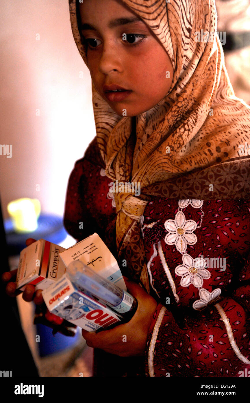 A Iraqi girl holds personal hygiene items and medicine after being ...