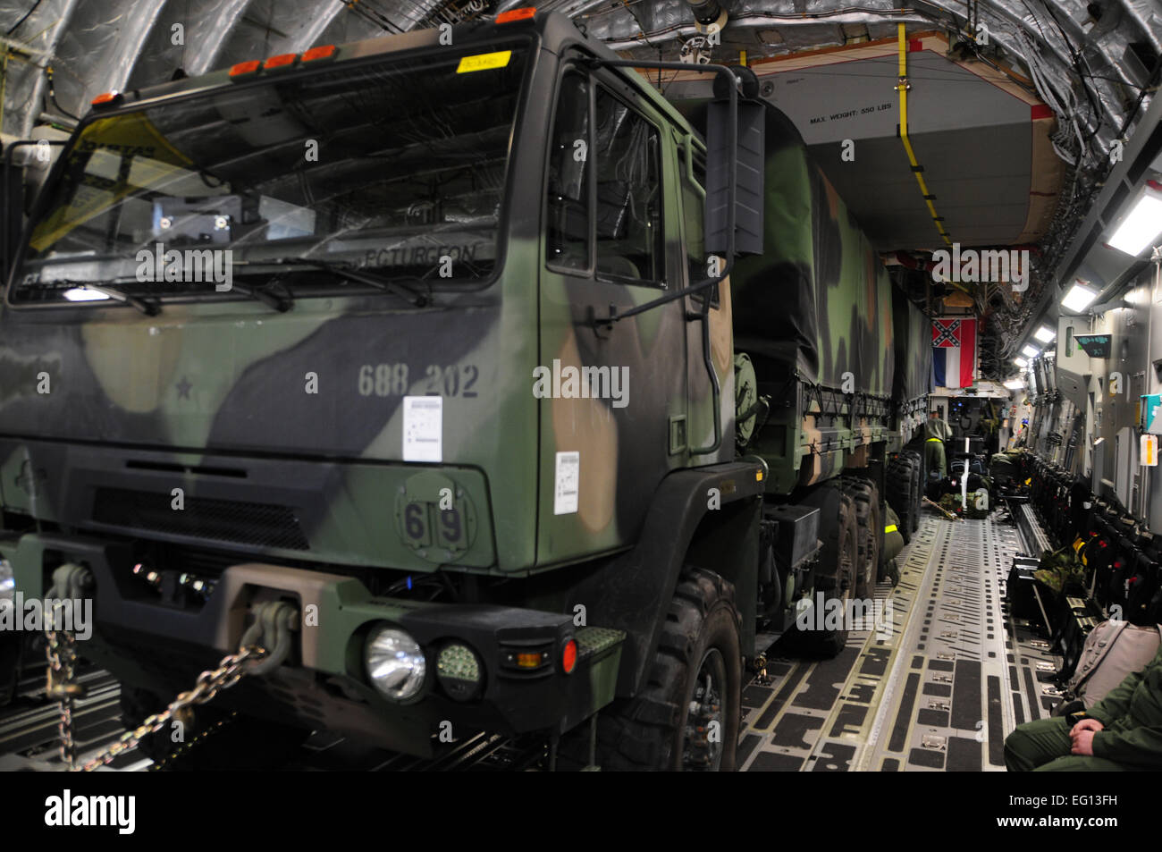Crews from C-17 Globemaster III cargo plane load military equipment in ...