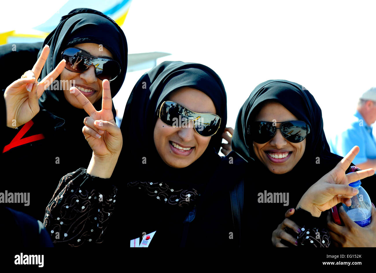 Three local Bahraini women stand in line and wait to be escorted into ...