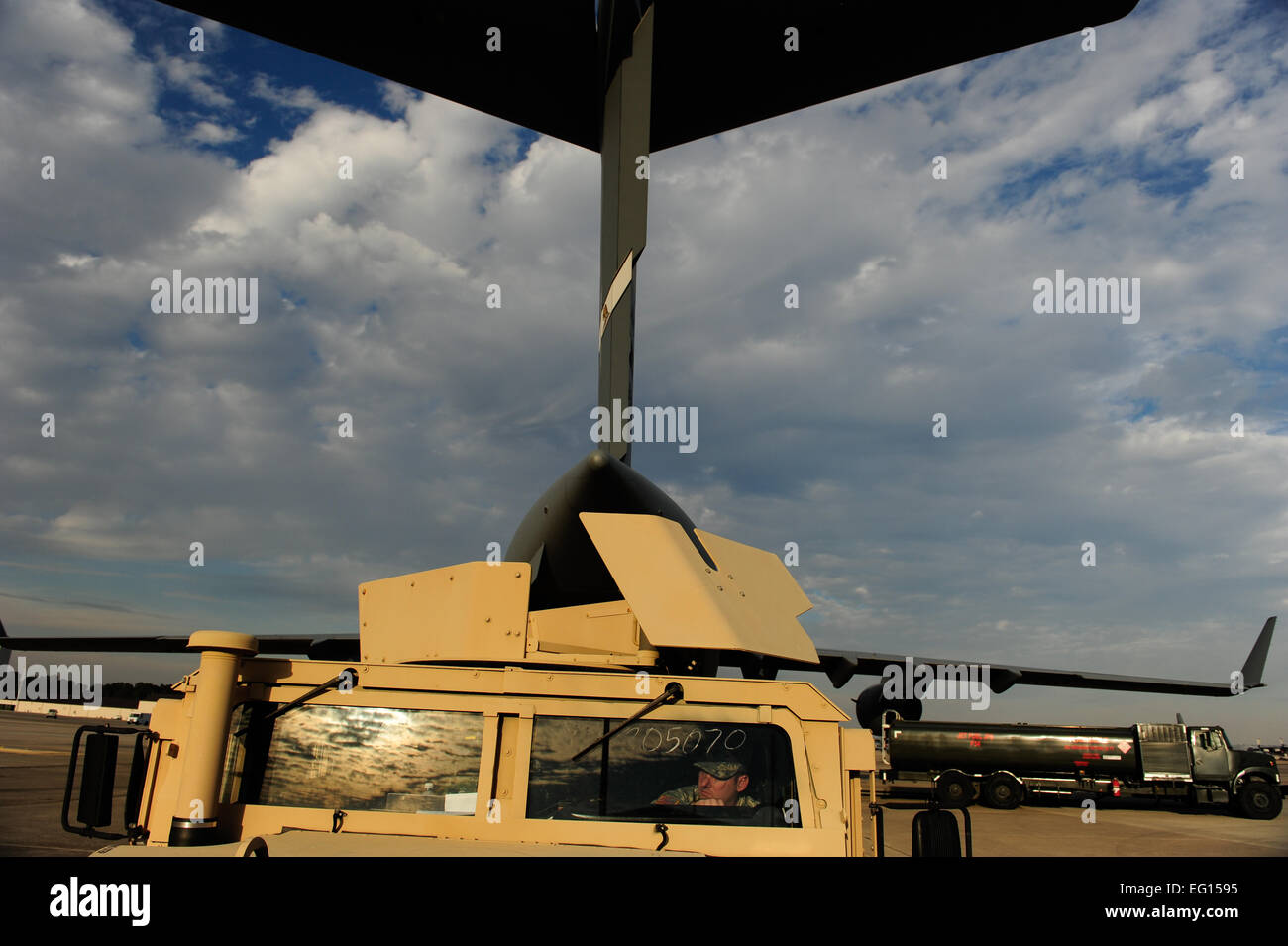 A U.S. Army Soldier waits in a HUMVEE while a U.S.Air Force C-17 ...