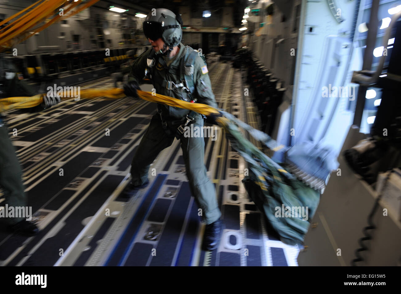 A loadmaster pulls parachute rigging into a C-17 Globemaster III June ...