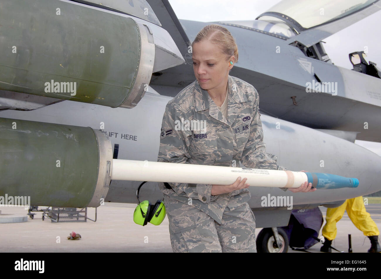 Airman 1st Class Kelly Sifers loads a practice rocket onto an F-16 ...