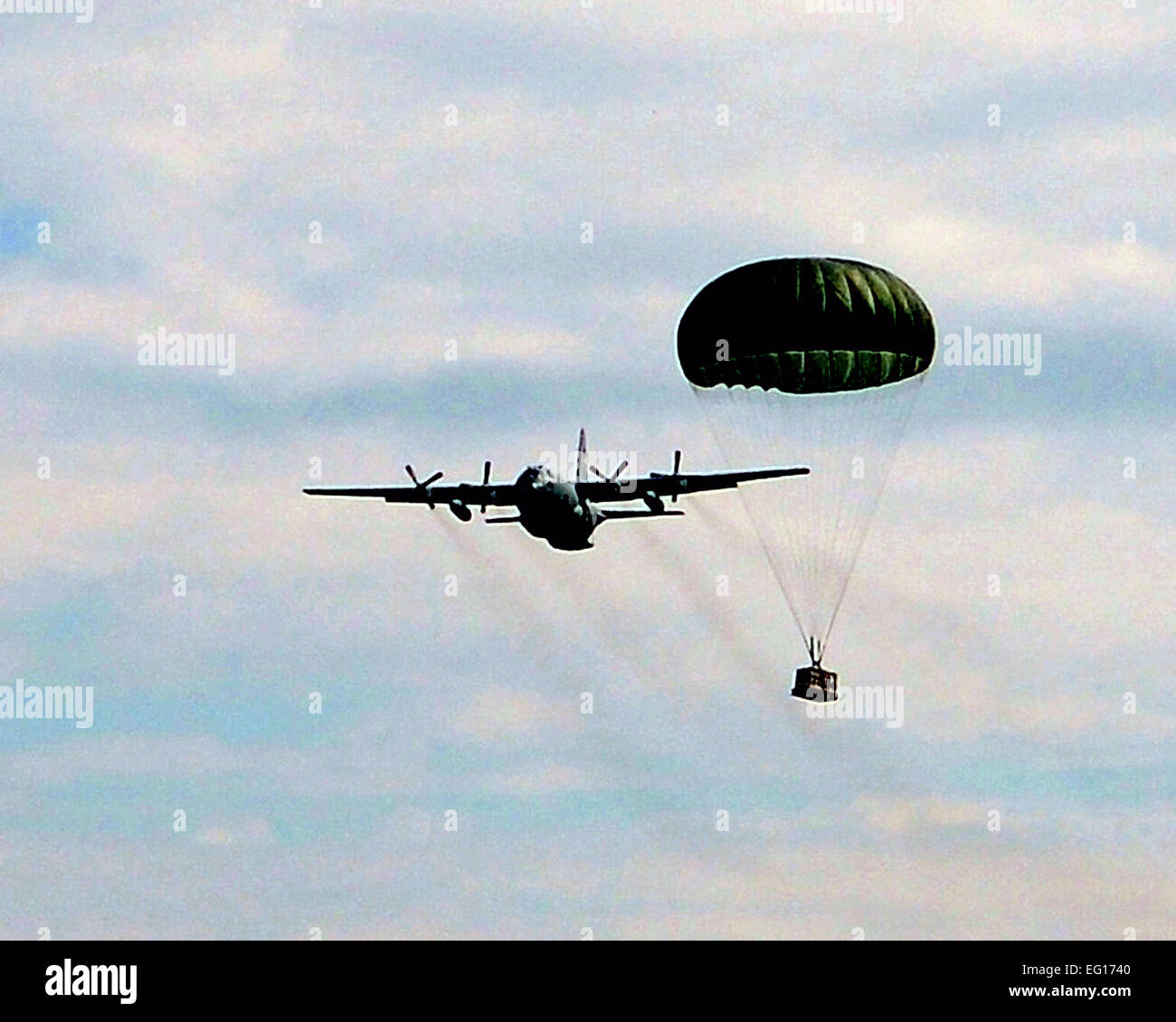 A "round" parachute carries a cargo load dropped out of a C-130 ...