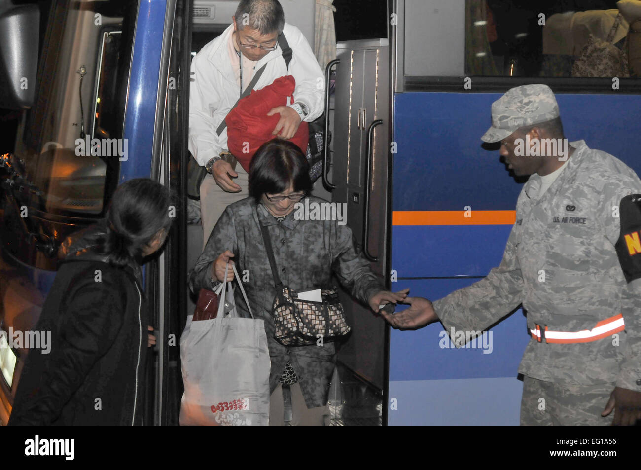 Suzuki Hideto left and U.S. Air Force Staff Sgt. Jason Holmes assist a ...