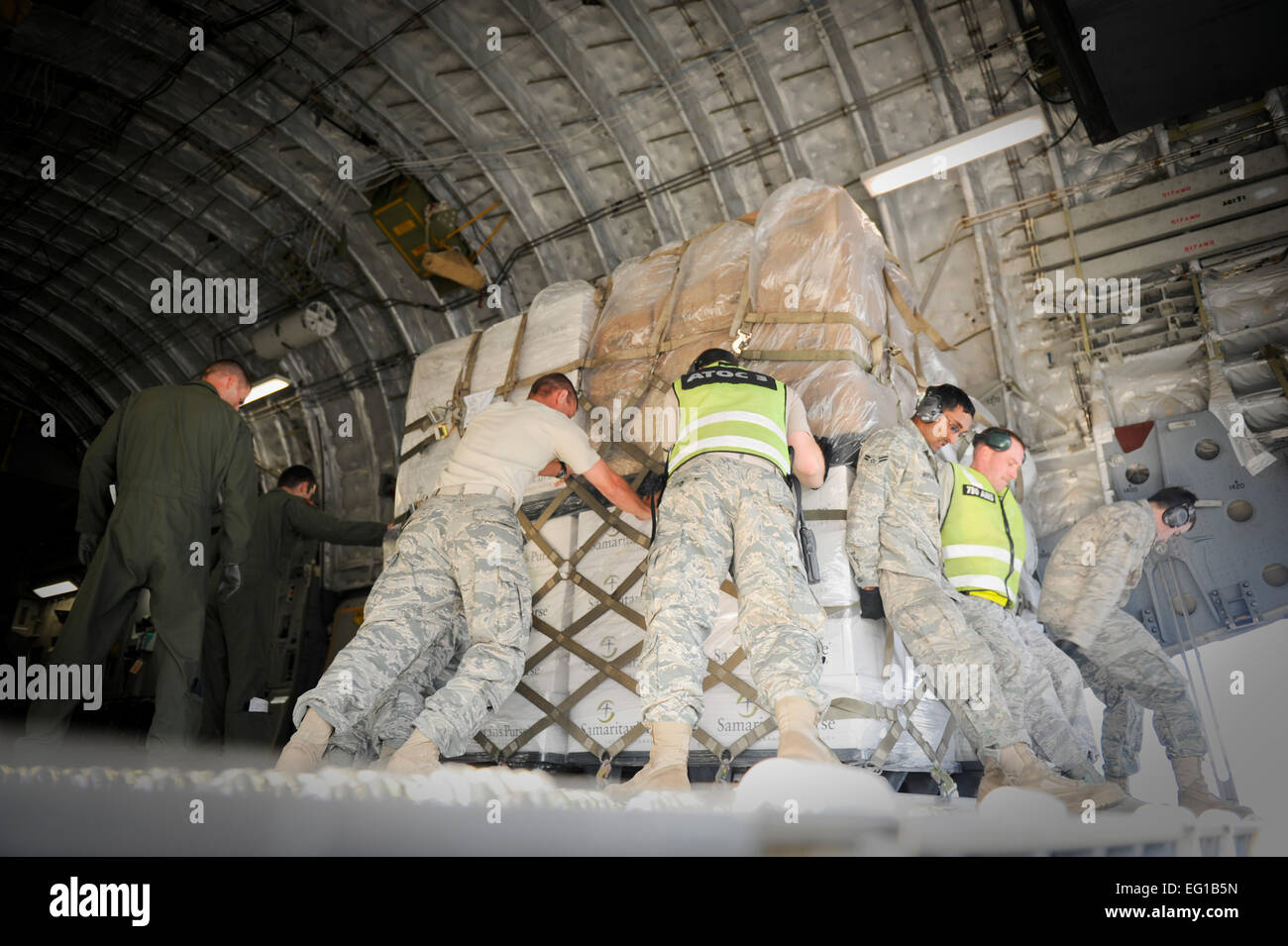 Members of the 730th Air Mobility Squadron push a pallet full of ...