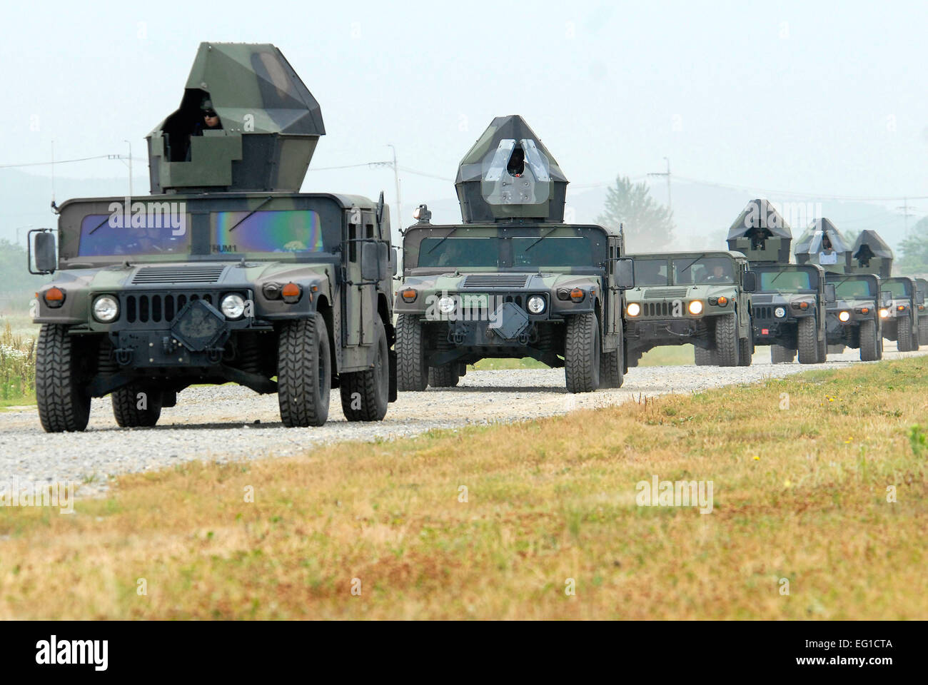 A convoy of humvees travels down a gravel road on Osan Air Base ...