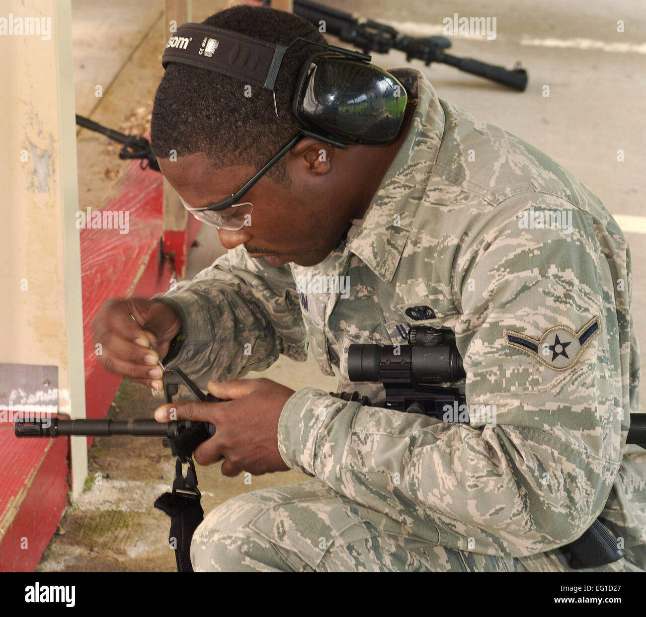 U.S. Air Force Airman Derrick Clark makes sight corrections on an M-4 ...