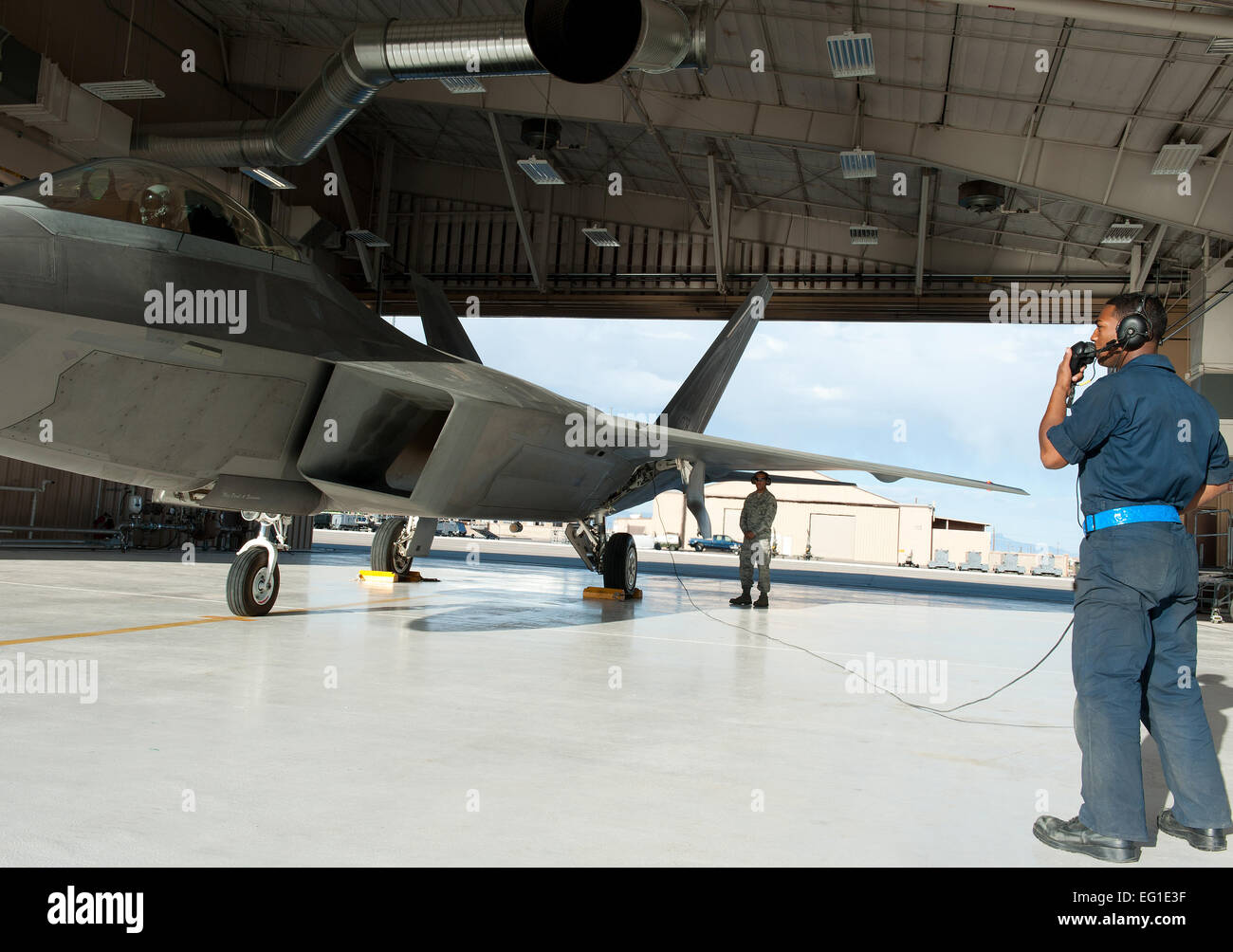 A U.S. Air Force F-22 Raptor fighter aircraft crew chief speaks with ...