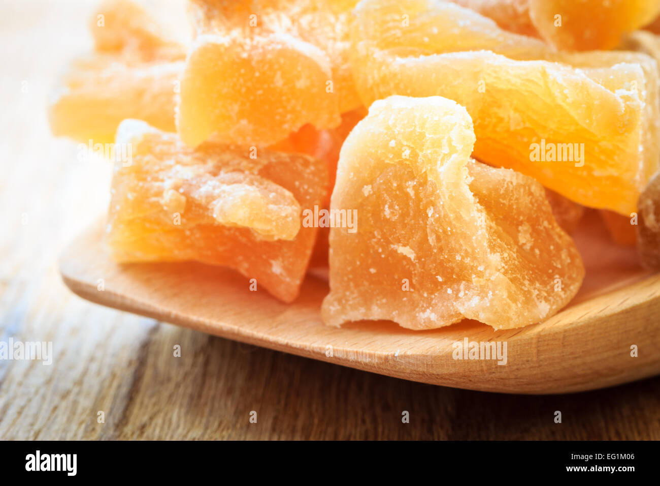 Closeup candied crystallized ginger candy pieces on wooden spoon ...