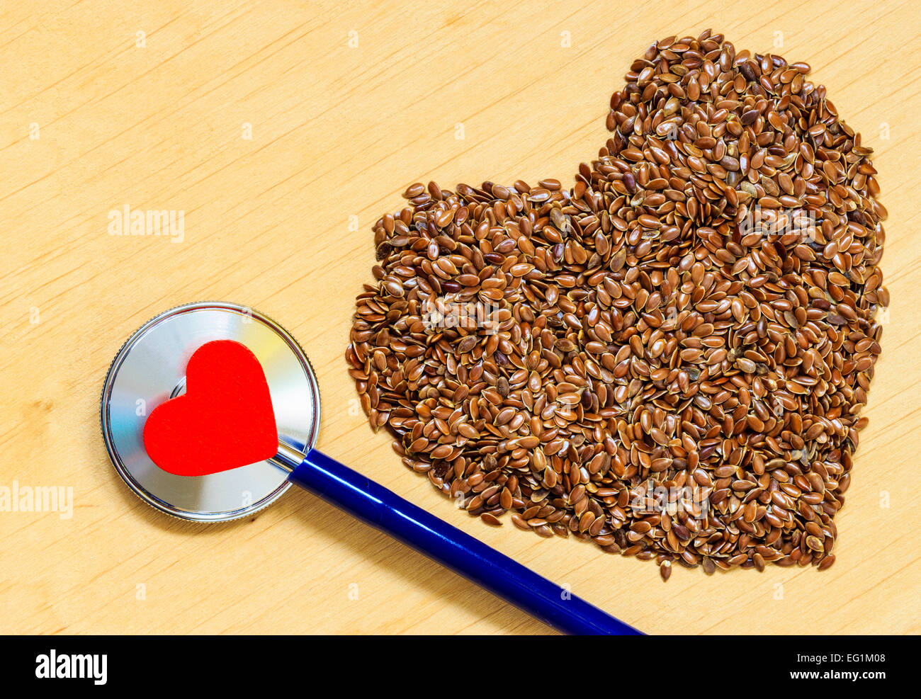Diet healthcare and checkup concept. Raw flax seeds linseed heart shaped and stethoscope ...
