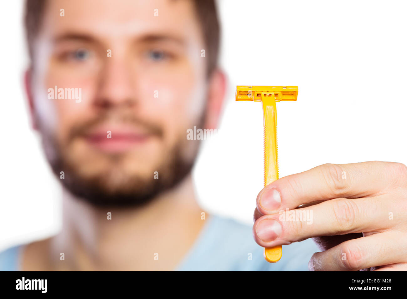 Young man guy with beard showing disposable yellow razor blade, studio ...