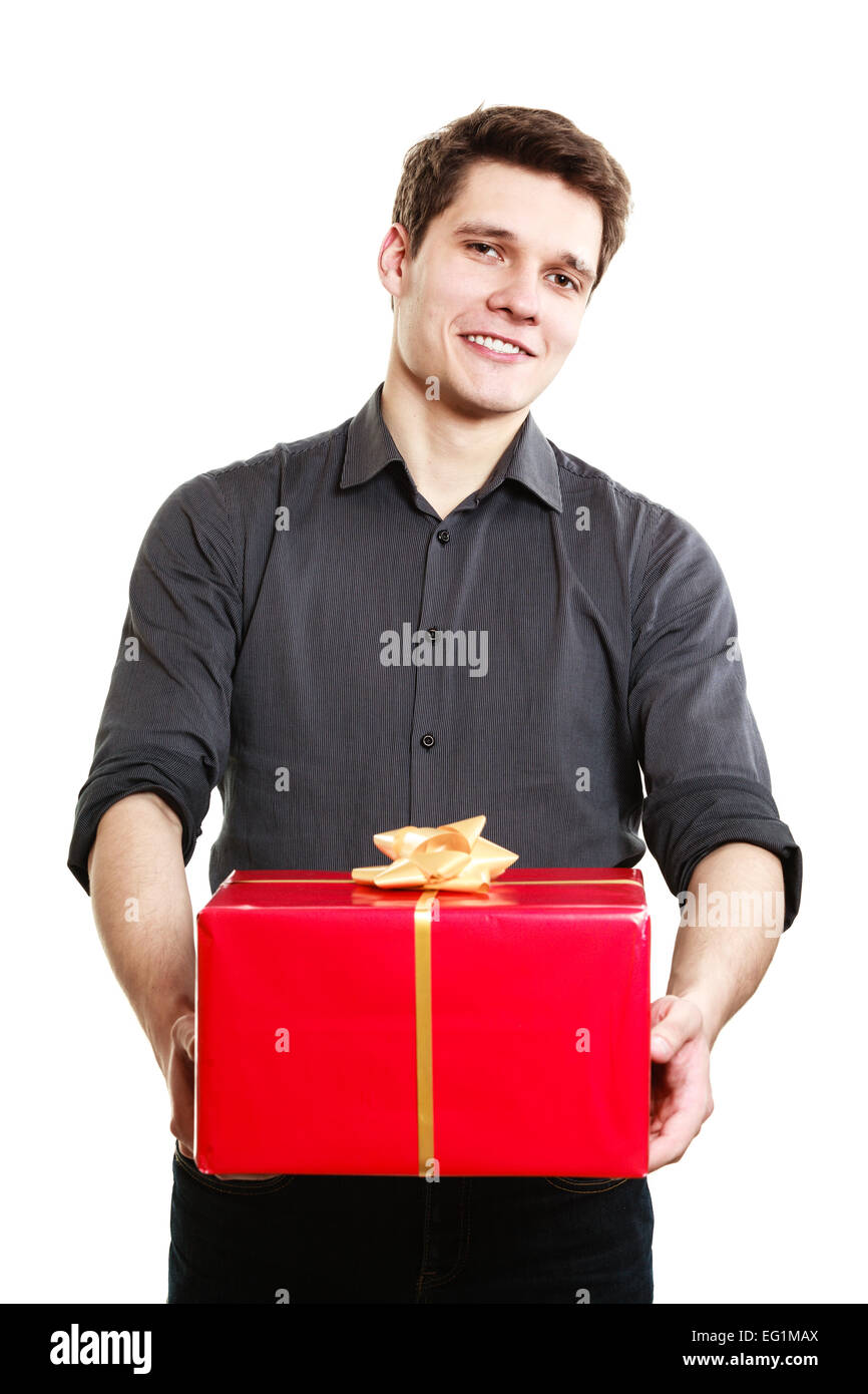 Holiday and special occasion. Young handsome man giving red present ...