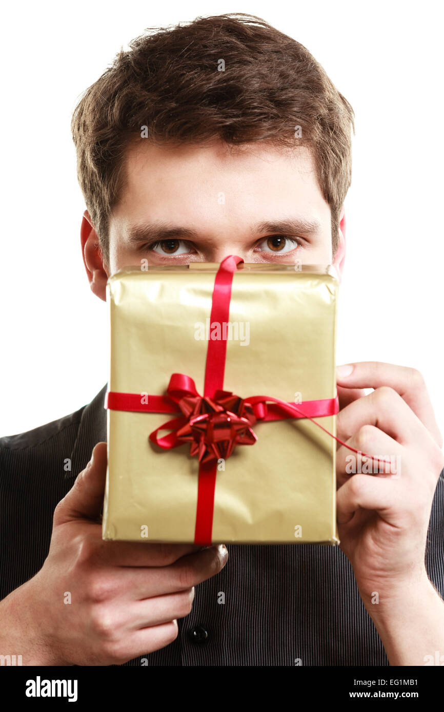 Holiday and special occasion. Young handsome man giving golden gift box ...