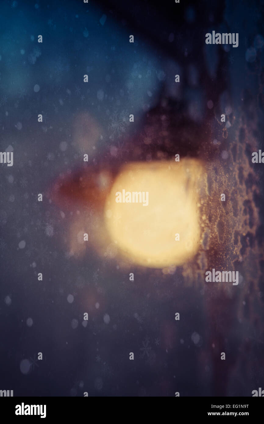 Porch light with soft focus in a snow storm as seen through a window ...
