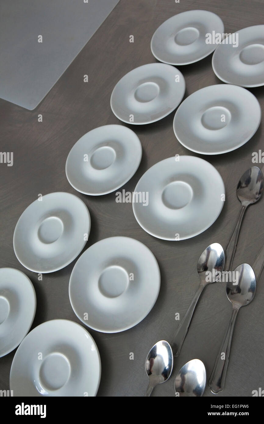 Spoons and plates on a table in a restaurant Stock Photo - Alamy