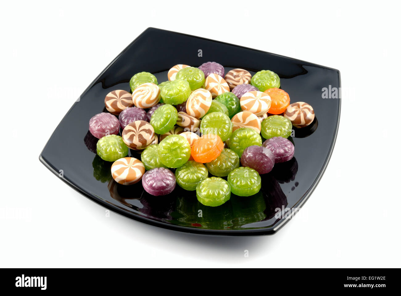Multi-coloured sweets sugar candies on a black plate Stock Photo - Alamy