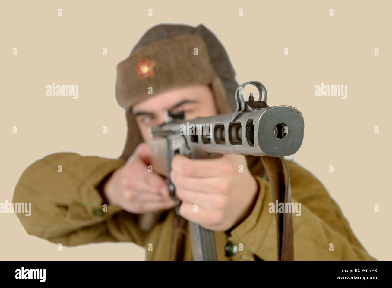 a young Soviet soldier fires with a machine gun on white background ...