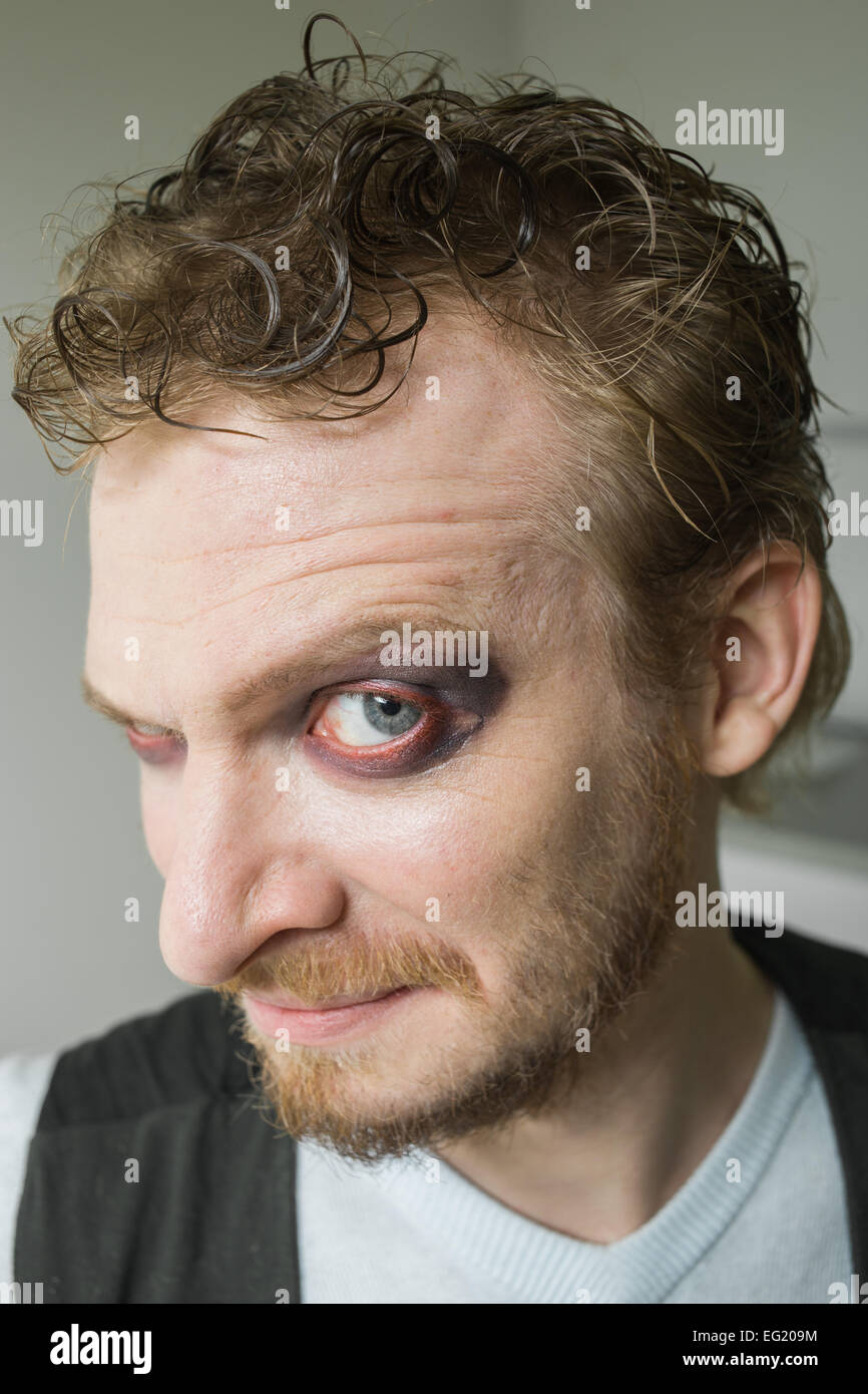 cunning man with red painted eyes Stock Photo - Alamy