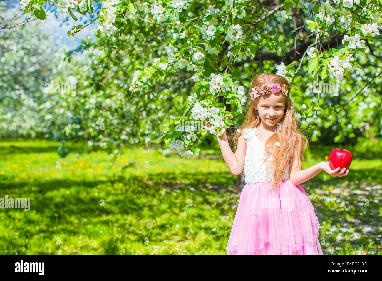 Happy little adorable girl in blossoming apple tree garden Stock Photo - Alamy