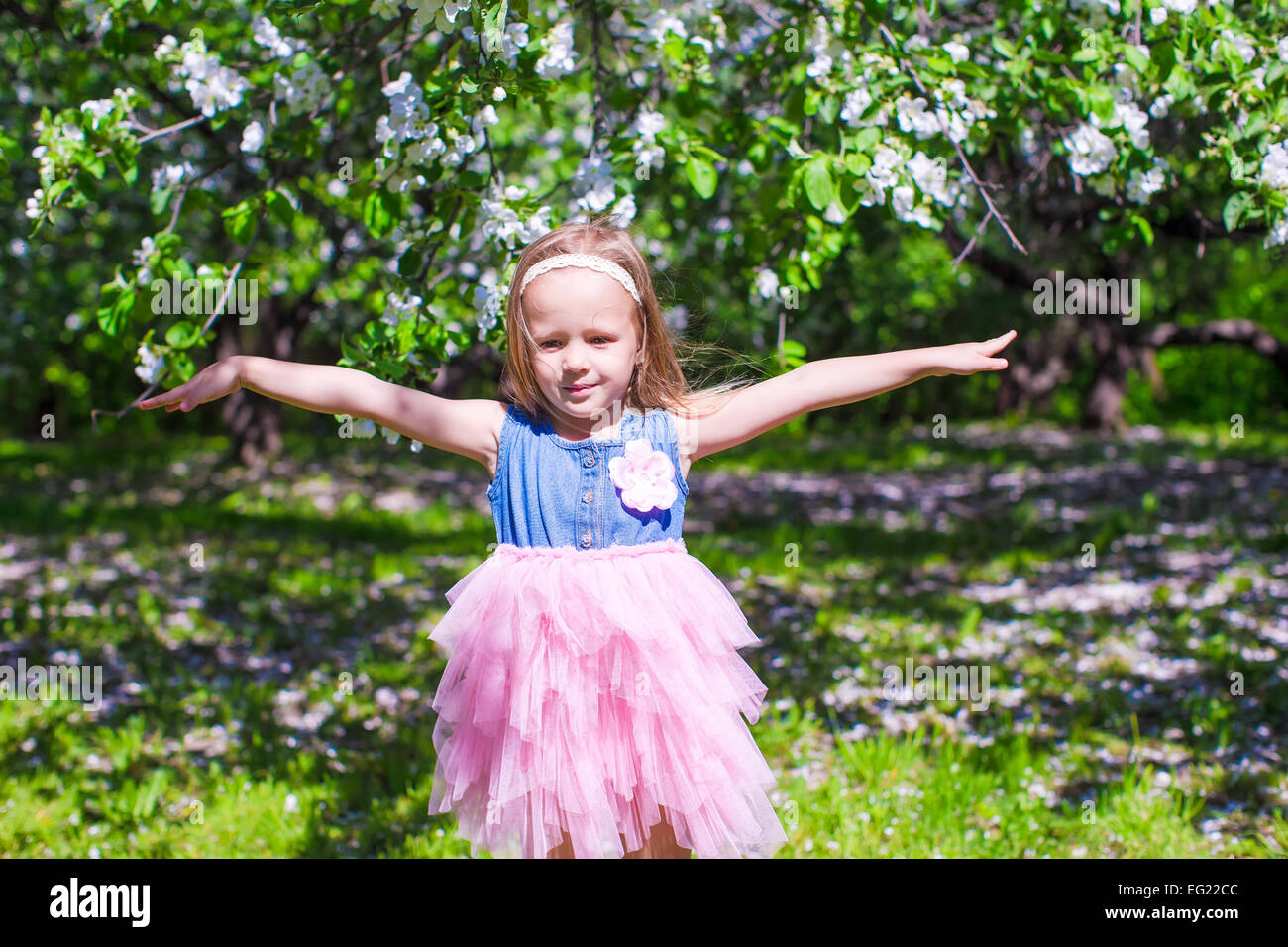 Adorable little girl in blooming apple tree garden on spring day Stock Photo - Alamy