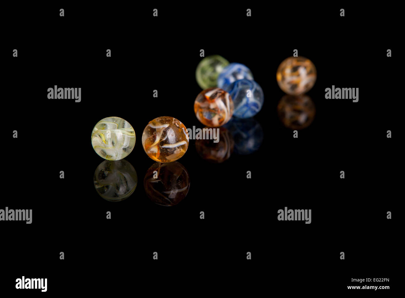 Colored marbles isolated over black background Stock Photo - Alamy