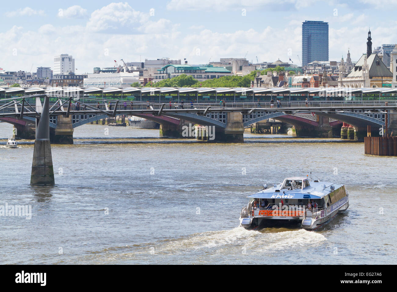 Thames Clipper boat passes under the Millennium Bridge on the River ...