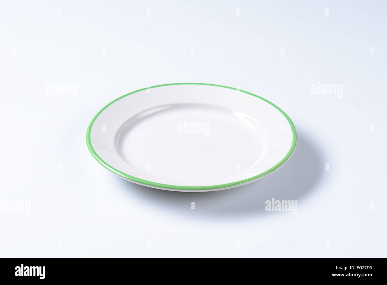 Rimmed dinner plate with green colored edge Stock Photo - Alamy