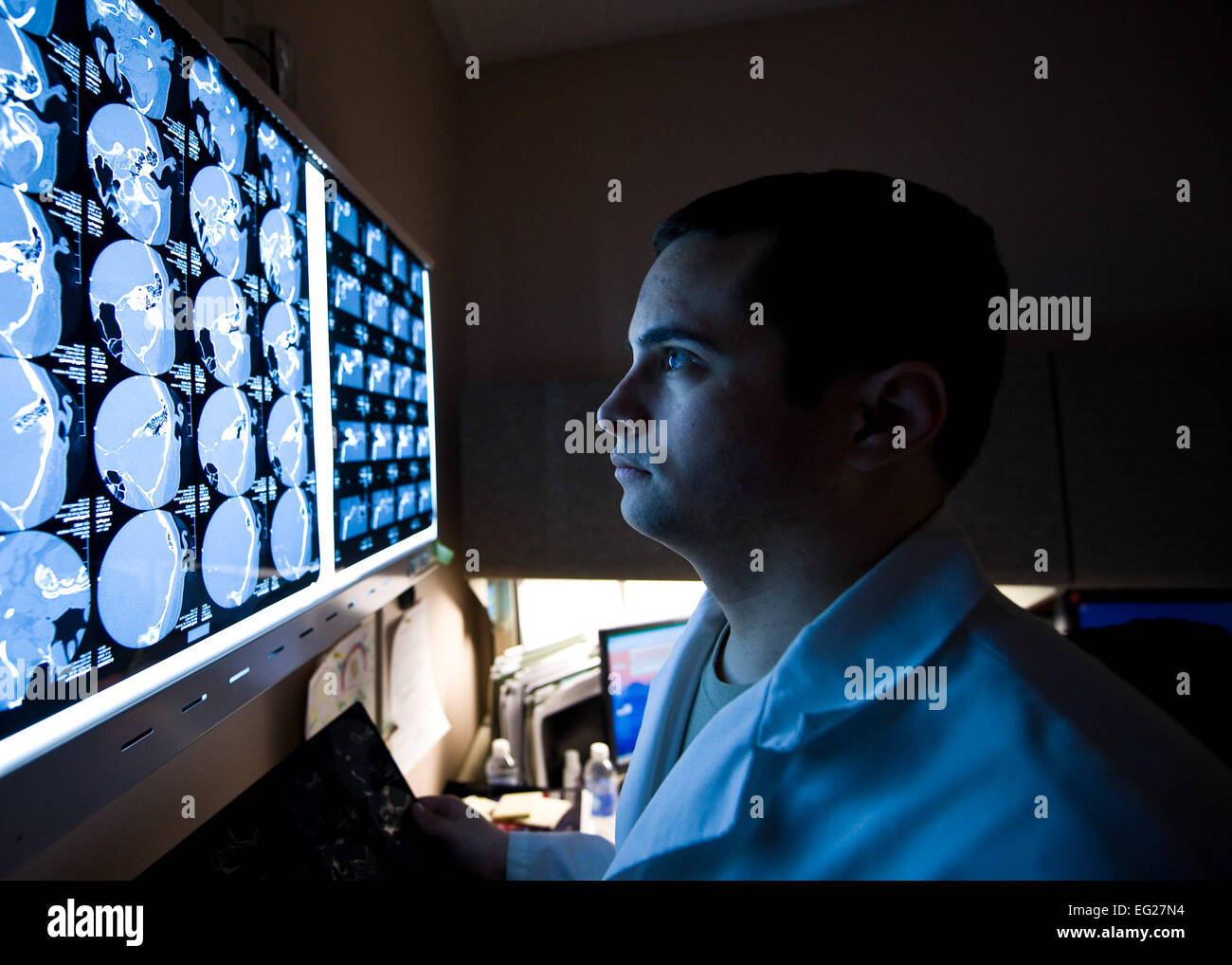 Capt. Dr. Wesley Reynolds studies a patient’s computed tomography scan ...