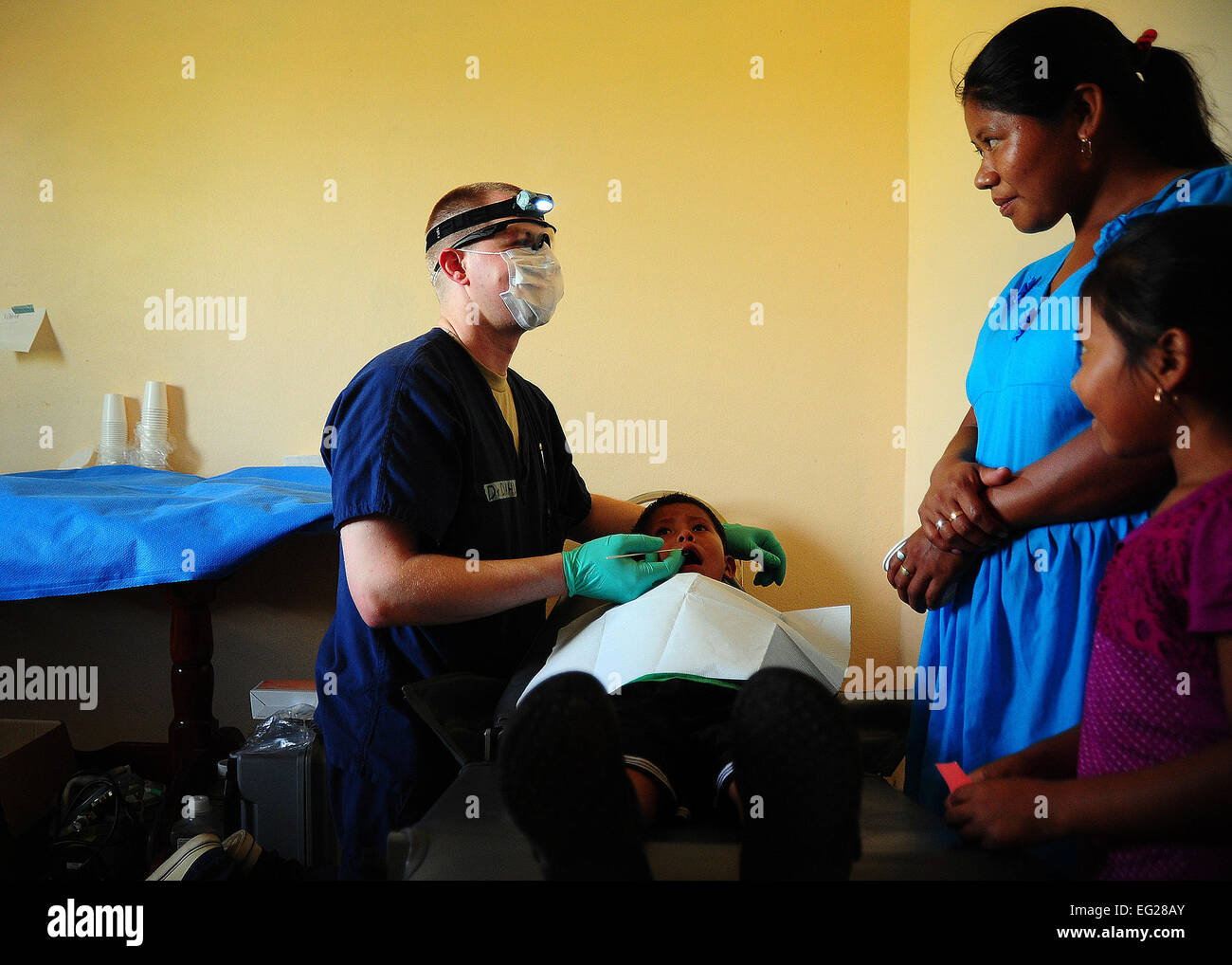 Capt. Daniel Dahl administers anesthesia to a Belizean boy while ...