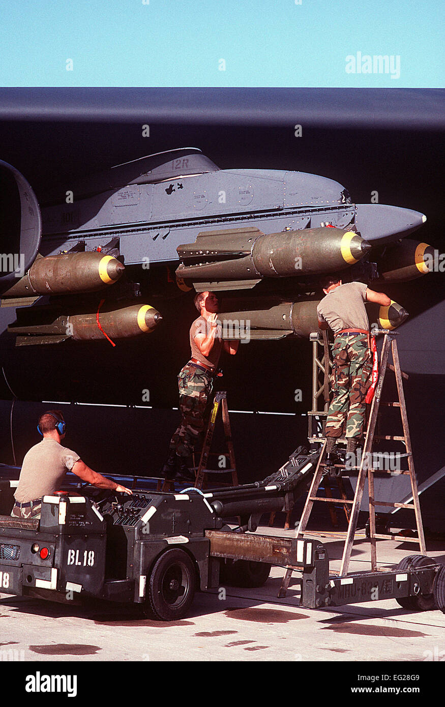 Ordnancemen use an MJ-1 bomb loader to load Mark 117 750-lb. bombs on a ...
