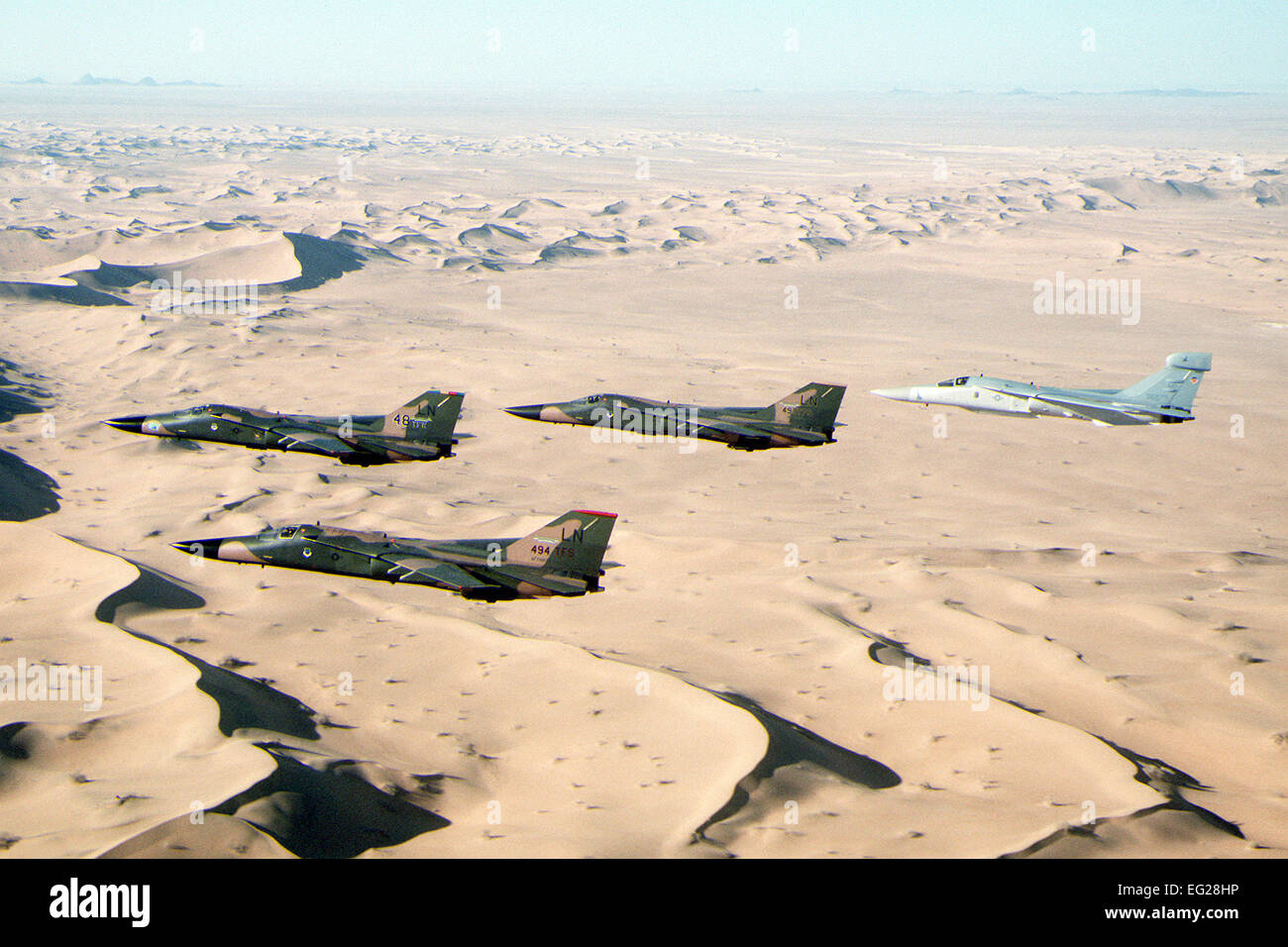 F-111F aircraft and an EF-111A Raven aircraft, rear, fly in formation ...