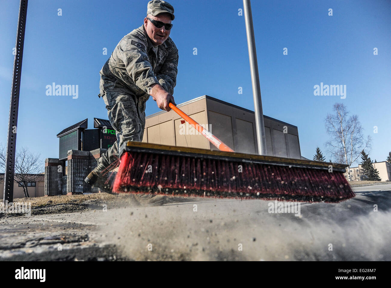 Staff Sgt. Justin Trammell sweeps dust and rocks off a sidewalk May 8 ...
