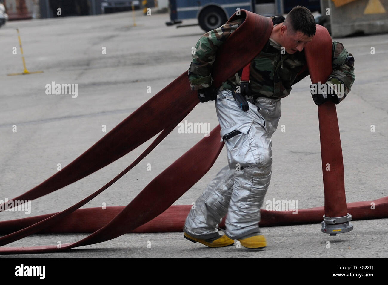 Senior Airman Dominic Schultz puts away fire hoses during an exercise ...