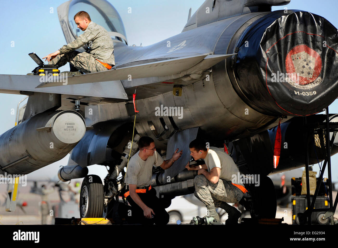 Crew chiefs perform maintenance checks on an F-16 Fighting Falcon ...