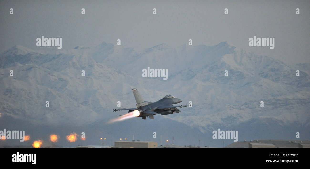 A U.S. Air Force F-16 Fighting Falcon takes off on a mission at dawn ...
