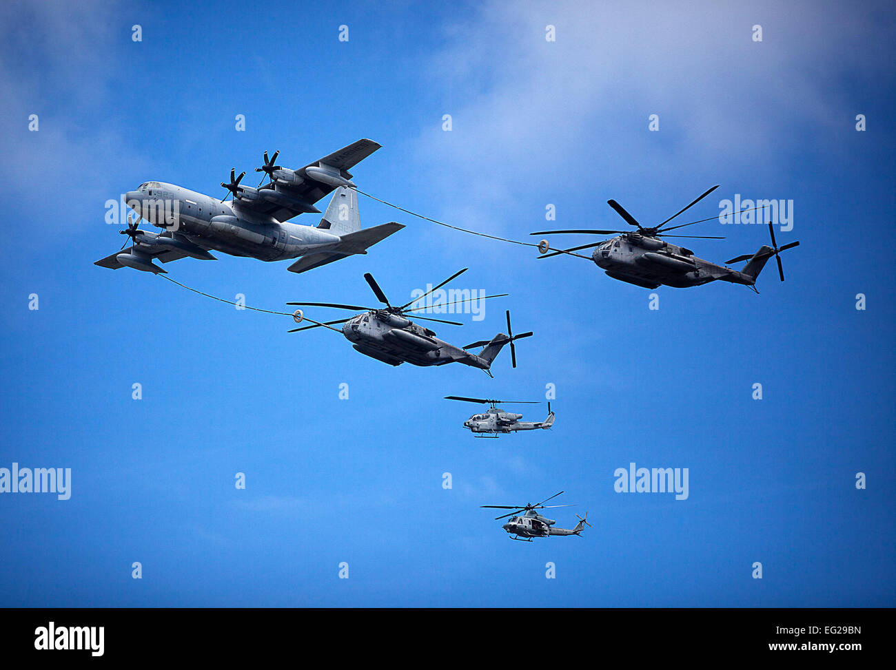 A U.S. Marine Corps C-130 left refuels two CH-53E Super Stallion ...