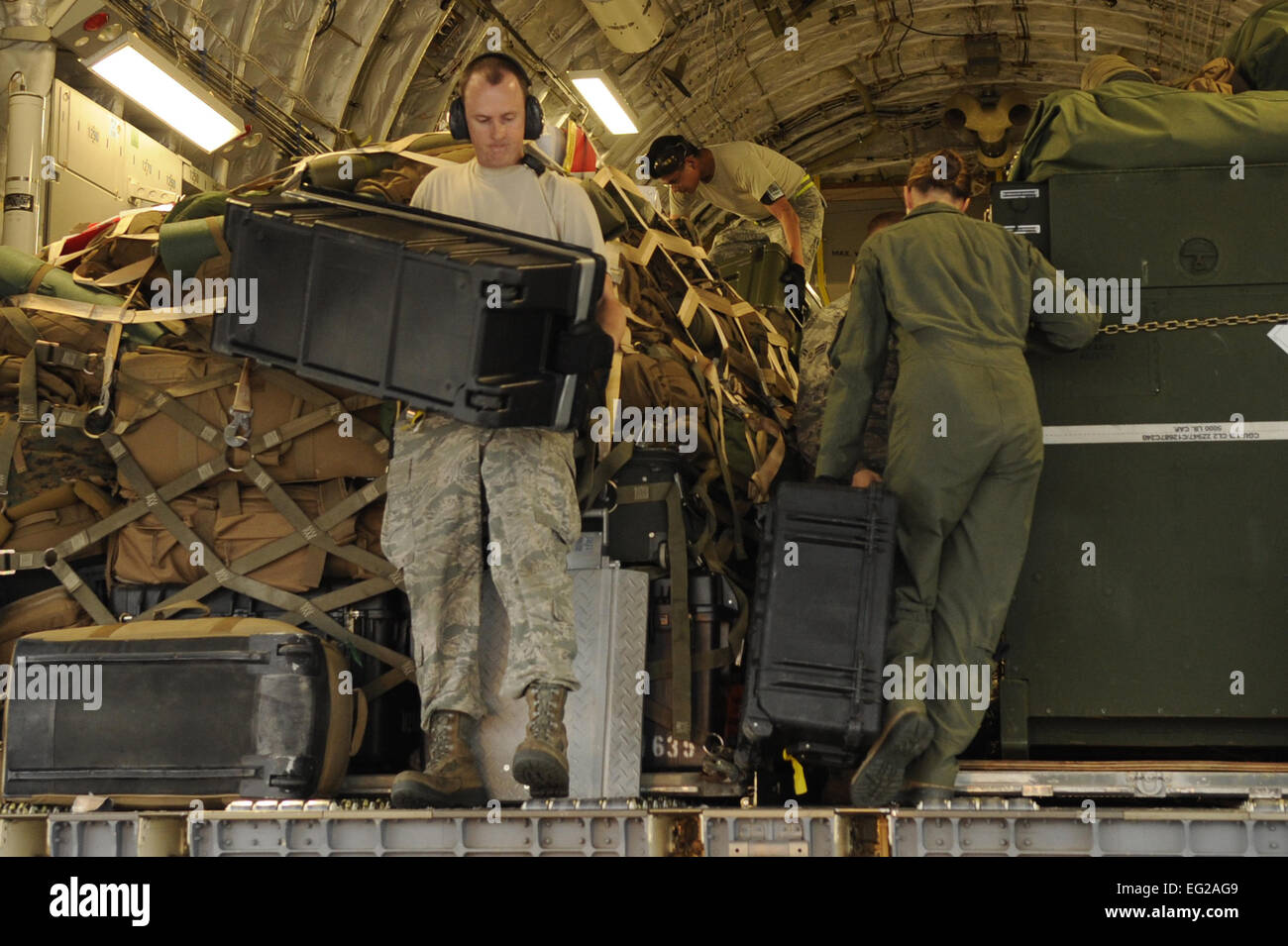 Airmen from the 733rd Air Mobility Squadron load supplies onto a C- 17 ...