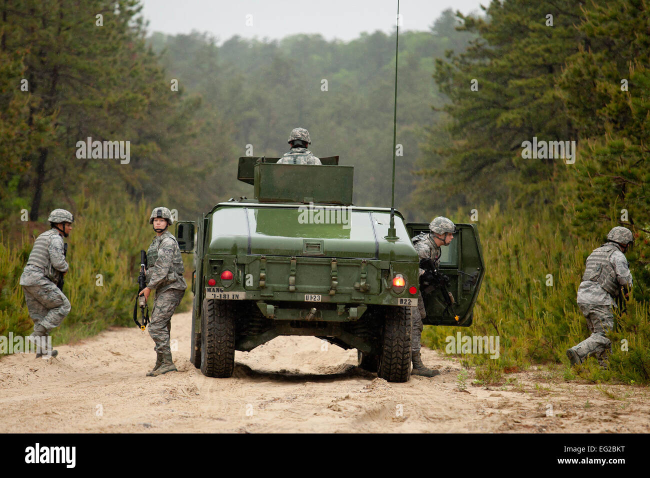Airman of the 102nd Security Forces Squadron scramble to defend against simulated weapons fire ...