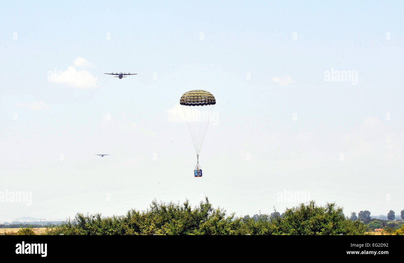 A container deployment system floats to the ground as two C-130J Super ...