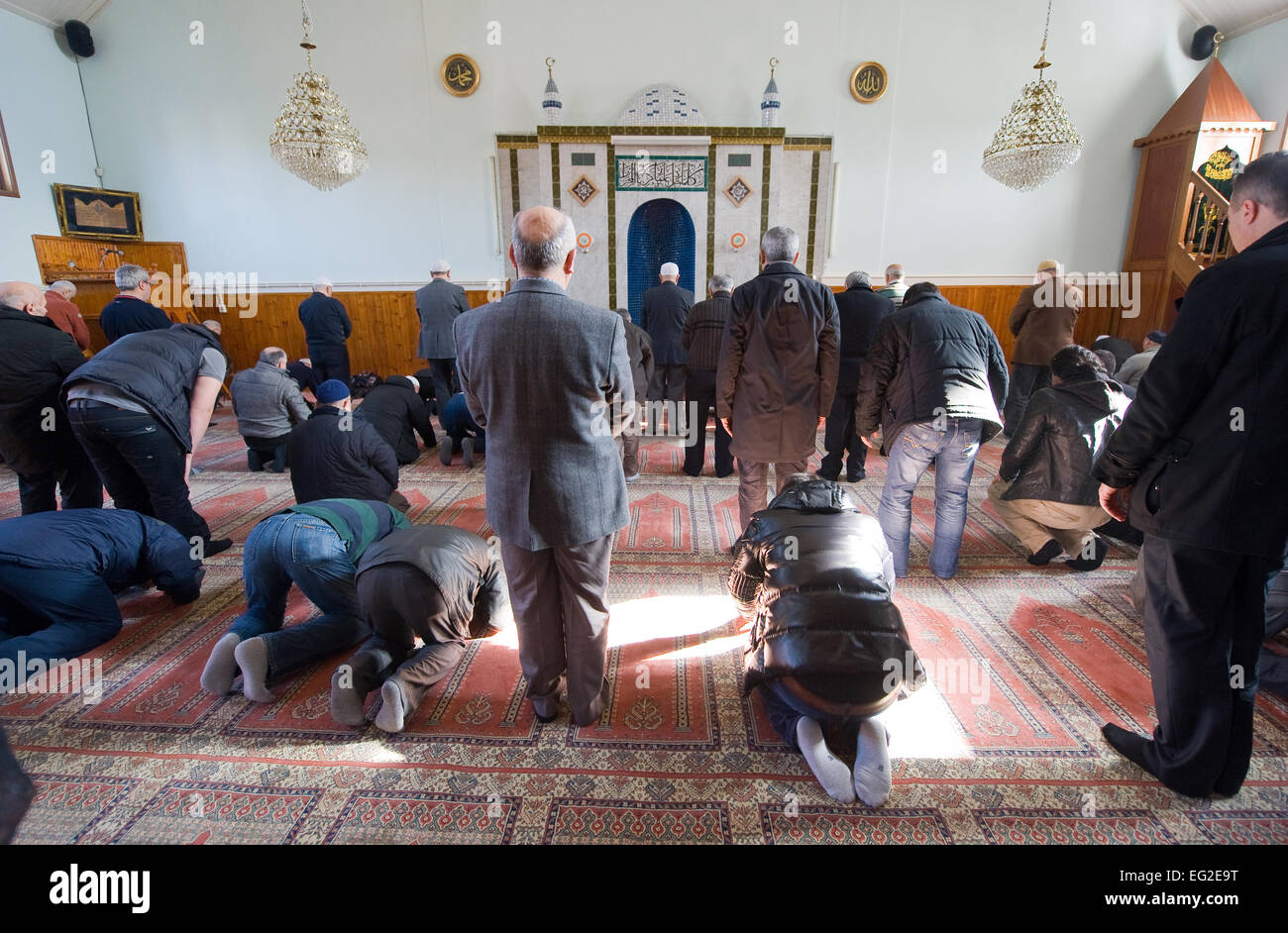 Muslims are standing and bowing during the friday afternoon prayer in a ...