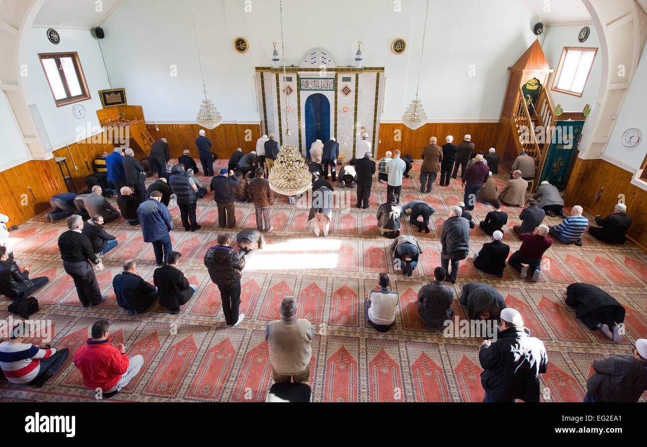 Muslims are standing and bowing during the friday afternoon prayer in a ...