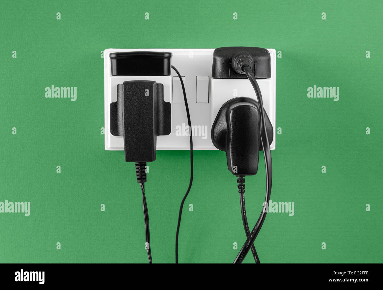 Battery chargers plugged in to outlet Stock Photo - Alamy