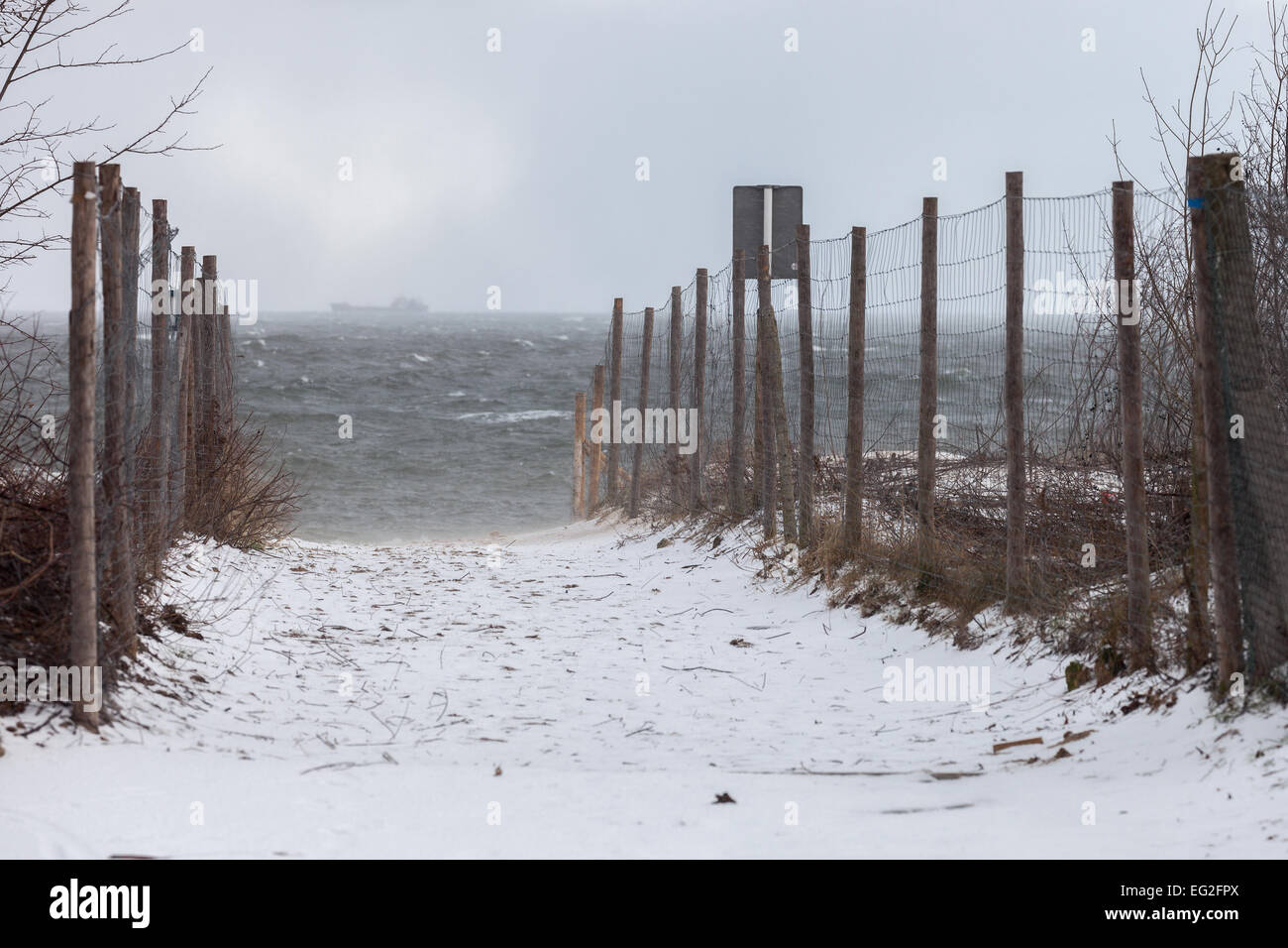 Entrance to the beach in a winter storm day during a violent blizzard ...