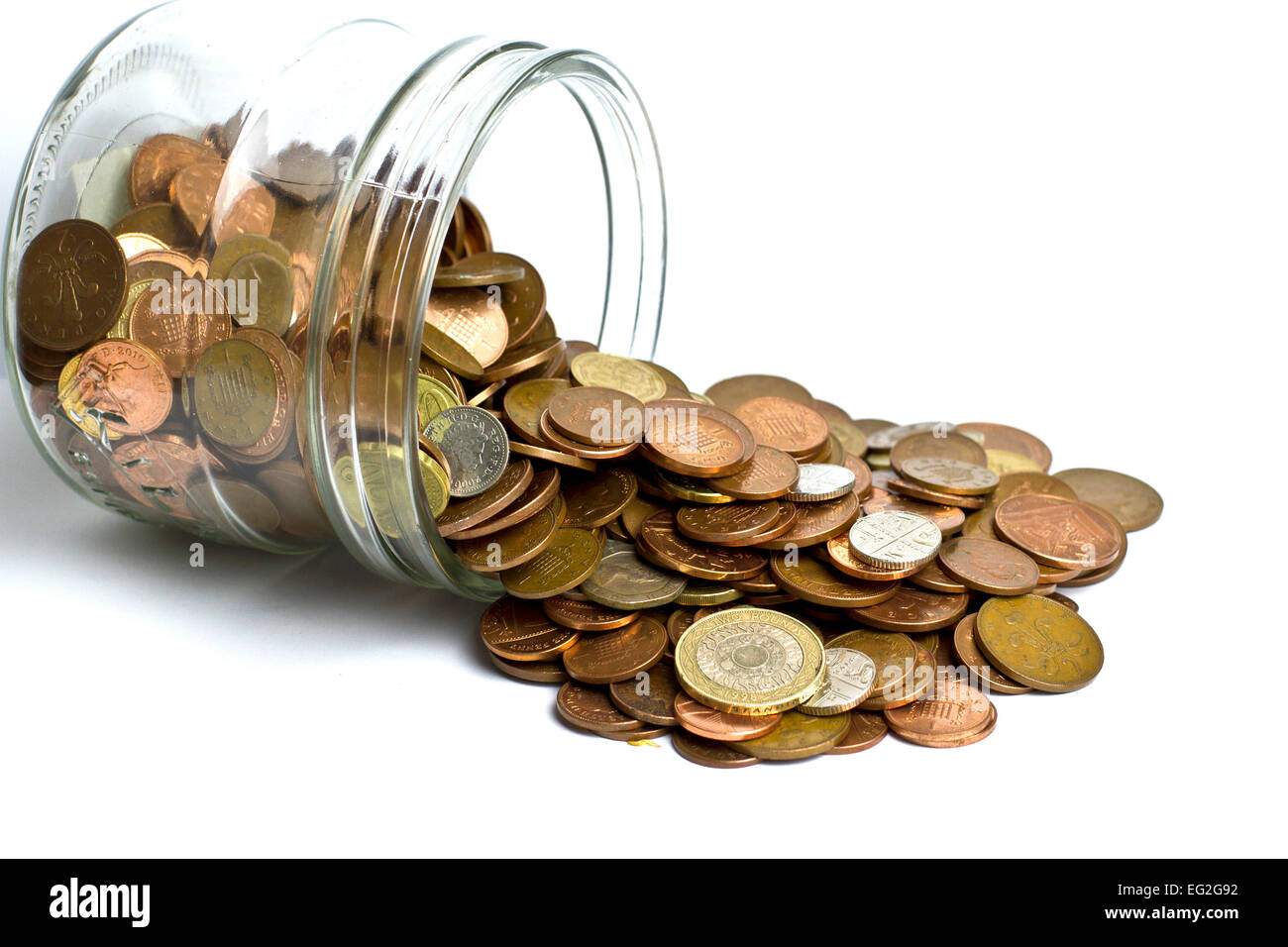 Coins spilling out of cash jar Stock Photo - Alamy