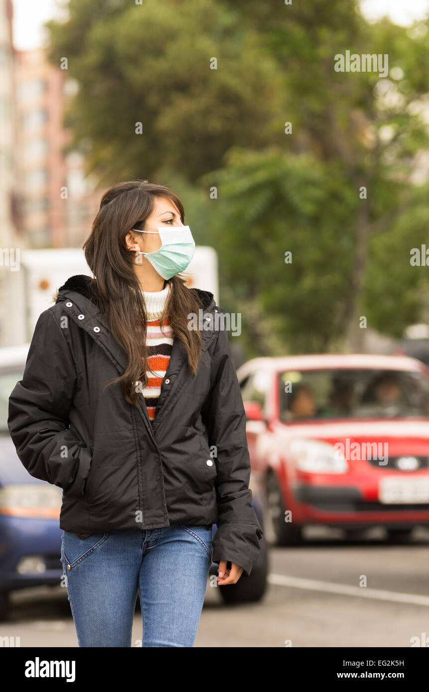 young girl walking wearing a mask in the city street concept of ...