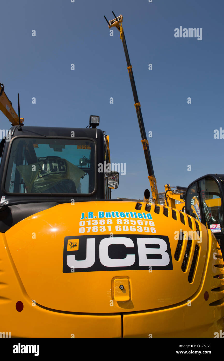 Under deep blue sky, close-up view of clean bright yellow JCB 8085 midi ...
