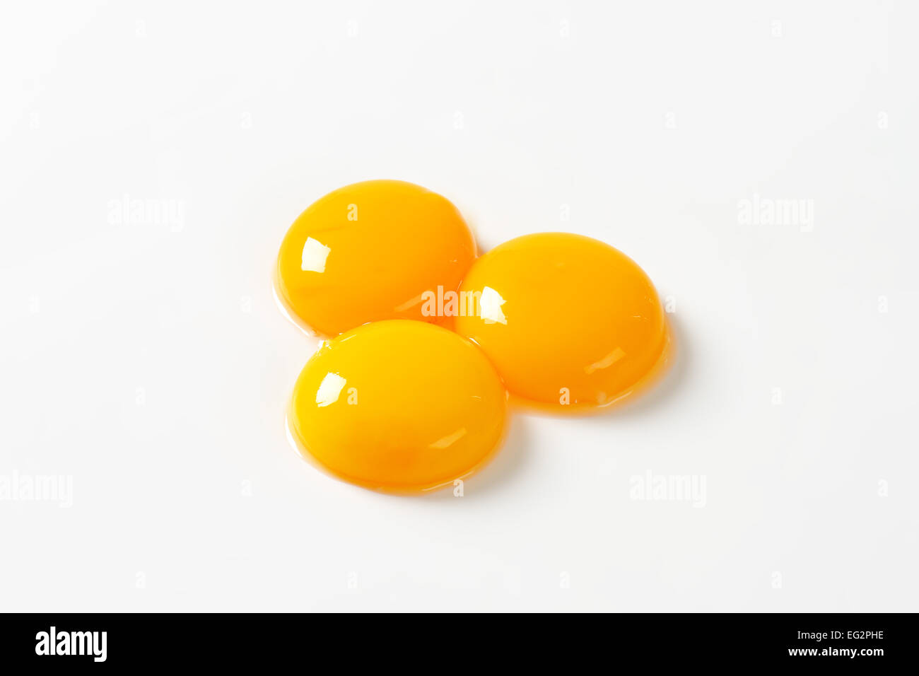 Raw egg yolk on white background Stock Photo - Alamy