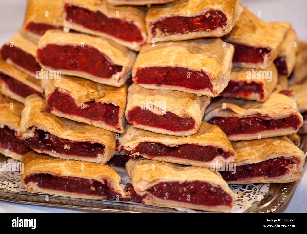 Group of cherry strudels with white dishes close up as a background ...
