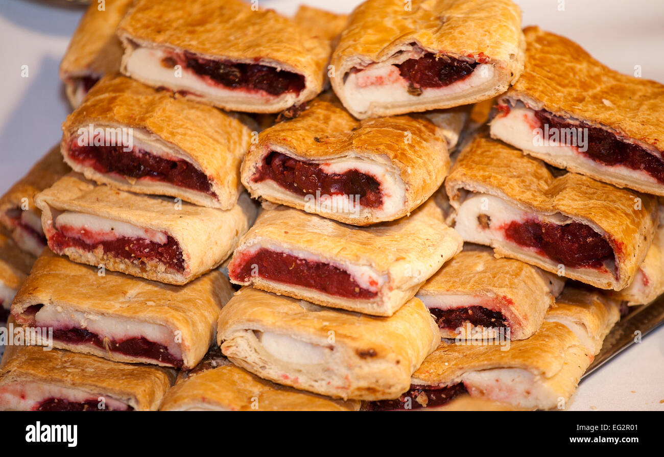 Group of cherry strudels with white dishes close up as a background ...